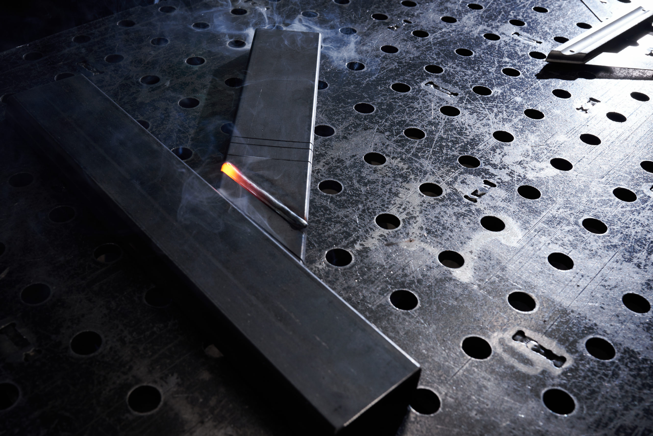 A red hot weld between two pieces of a metal pipe cools down – Black ...